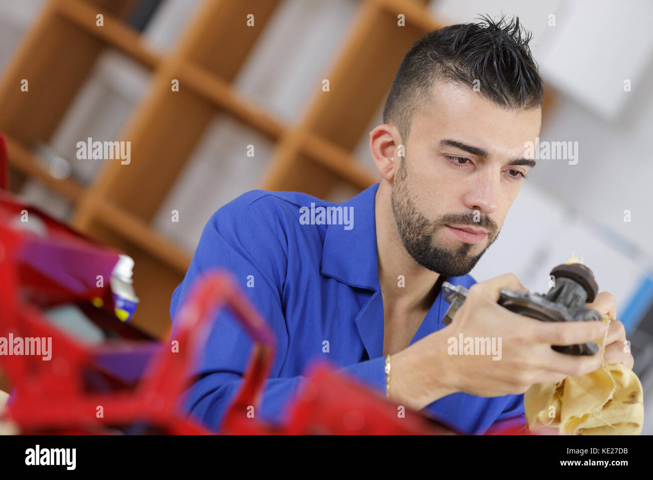 male engineer cleaning cog Stock Photo - Alamy