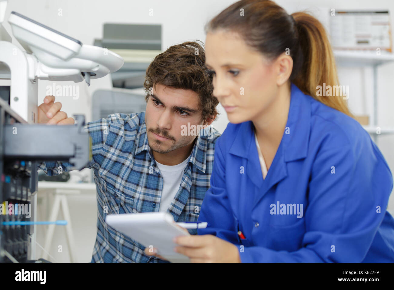 engineer and apprentice working on machine in factory Stock Photo - Alamy