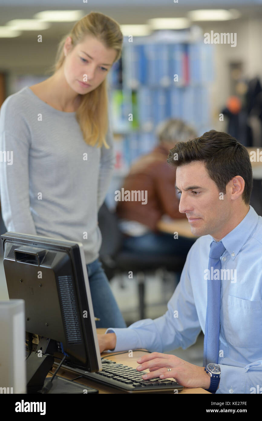 woman supervising man using computer Stock Photo - Alamy