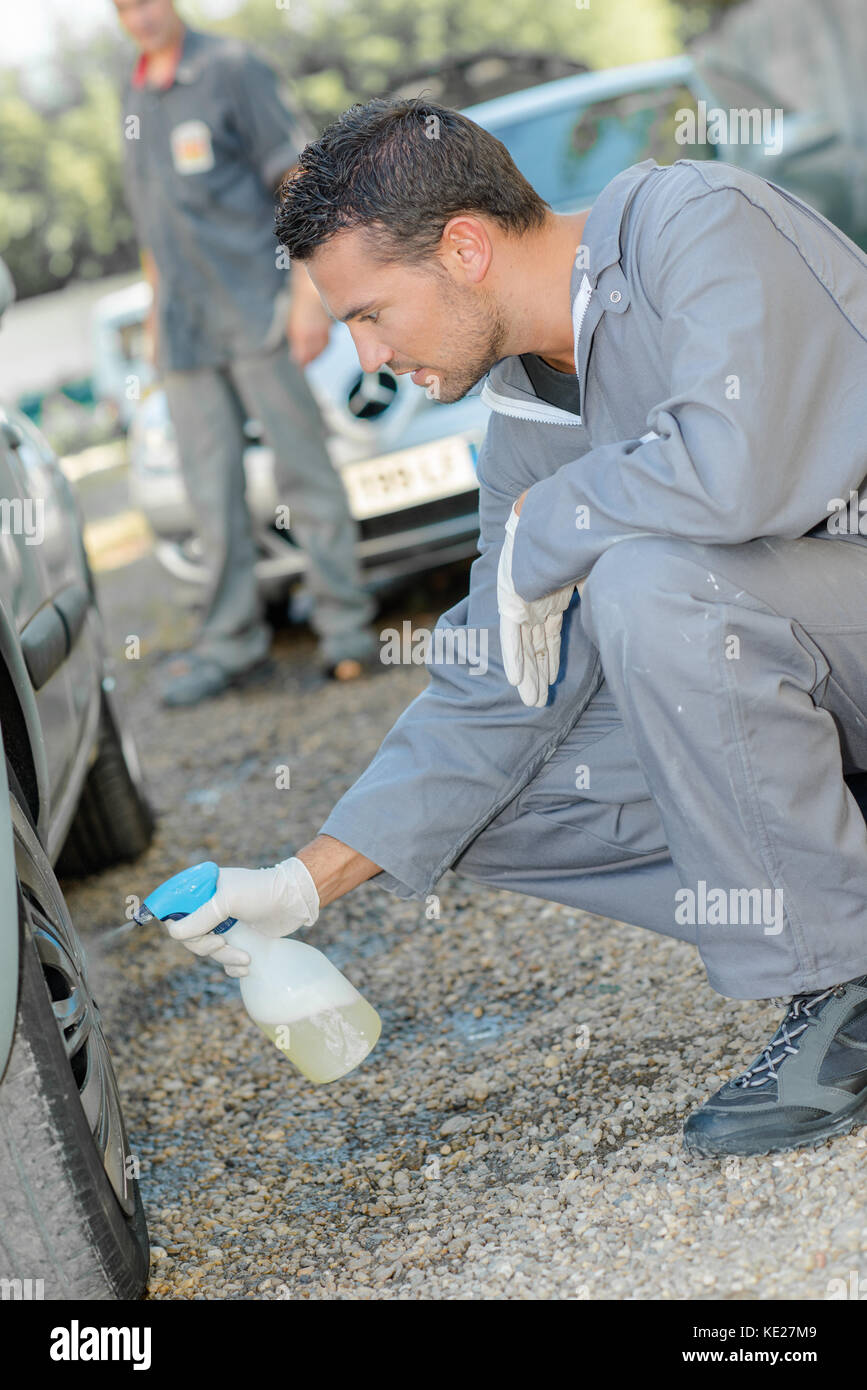 Mechanic washing a customer's car wheels Stock Photo - Alamy