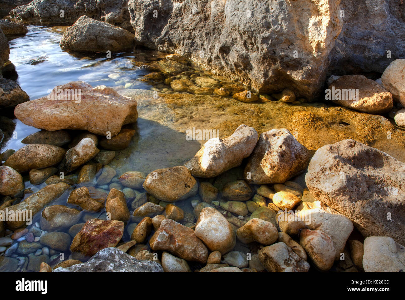 Colourful stones and rocks laying in shallow seawater at Selmun Bay ...
