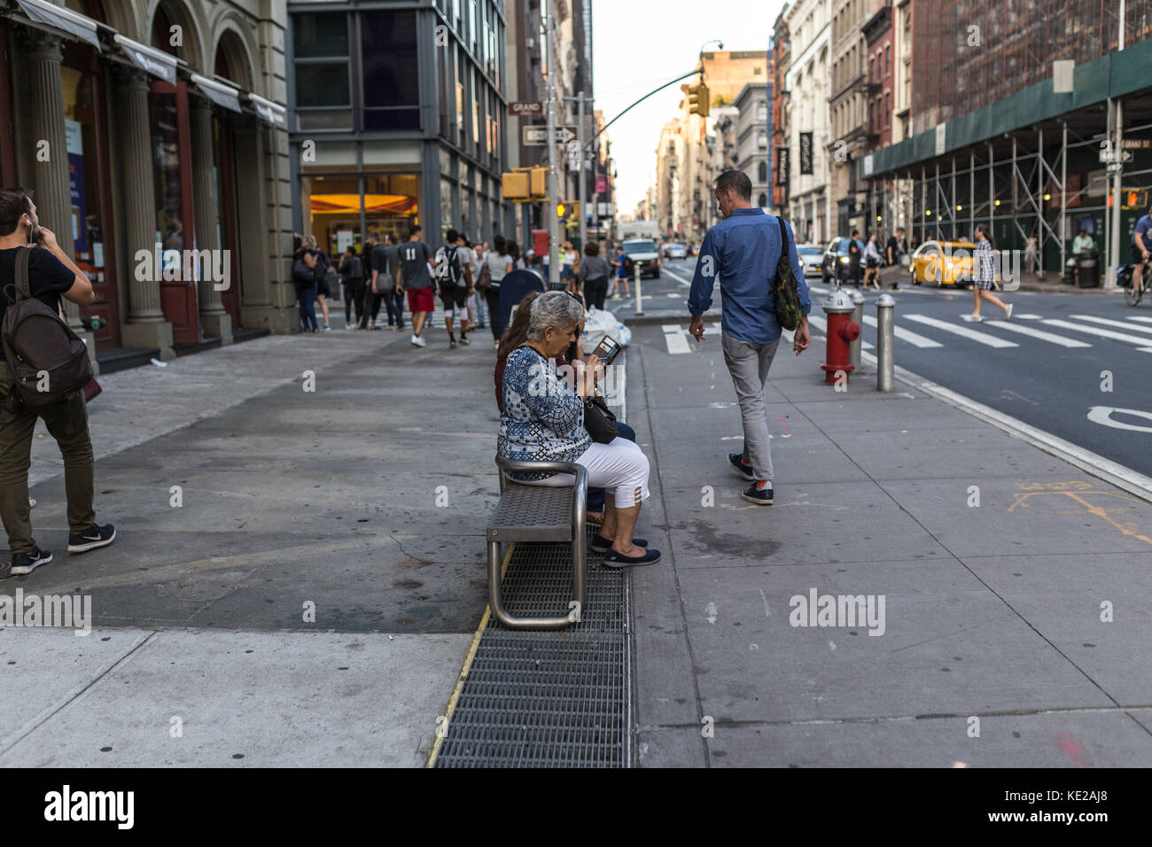 Pedestrians and people sitting on benches on Broadway, Soho, NY Stock ...