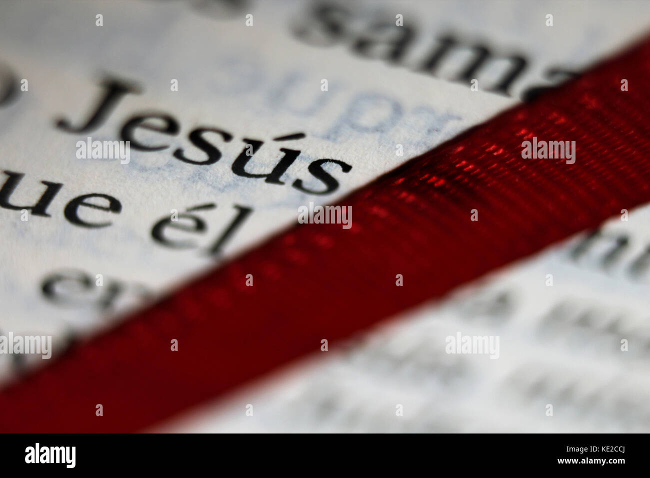 Close-up of an open holy bible with red bookmark and focus on the word ...