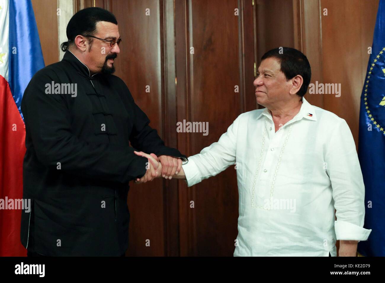 Philippine President Rodrigo Duterte, right, shakes hands with action ...