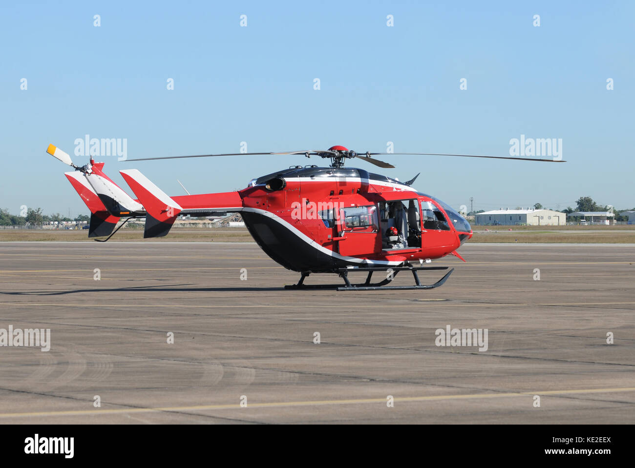 Modern red helicopter preparing for flight Stock Photo - Alamy