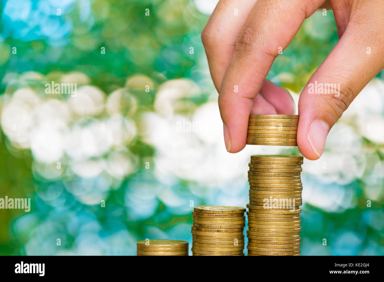Woman hand put coin on step of coins stacks and gold coin money in the ...