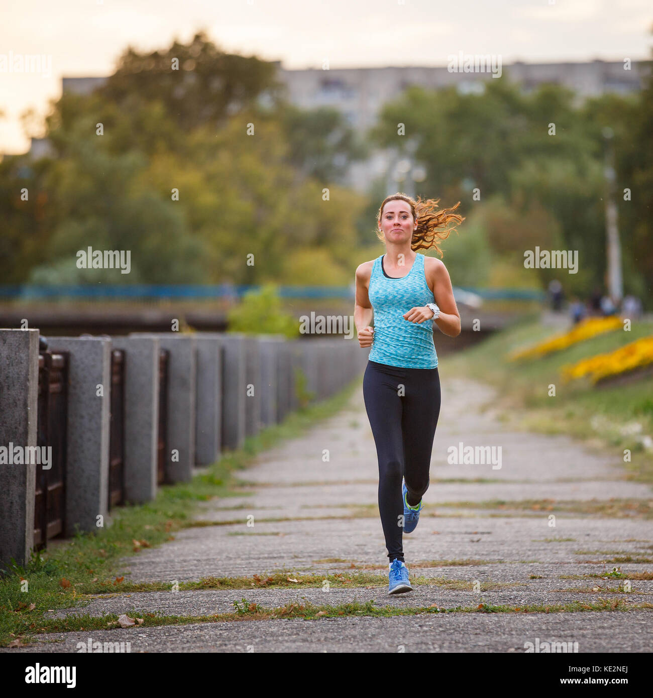 Young beautiful woman running in park in the morning. Sporty girl ...
