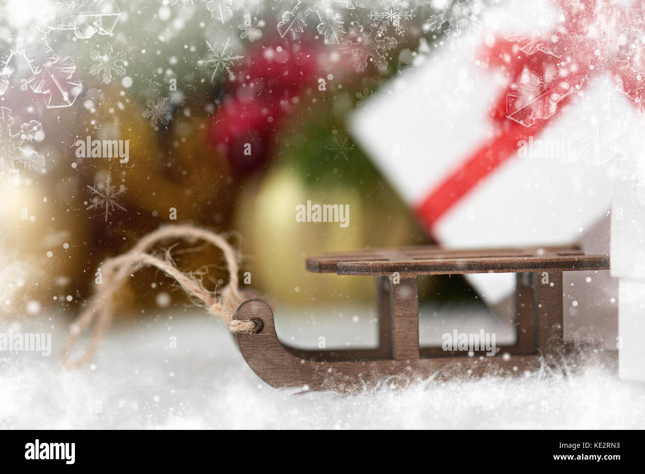 toy sleigh and Christmas decorations as background, decorated with snow ...