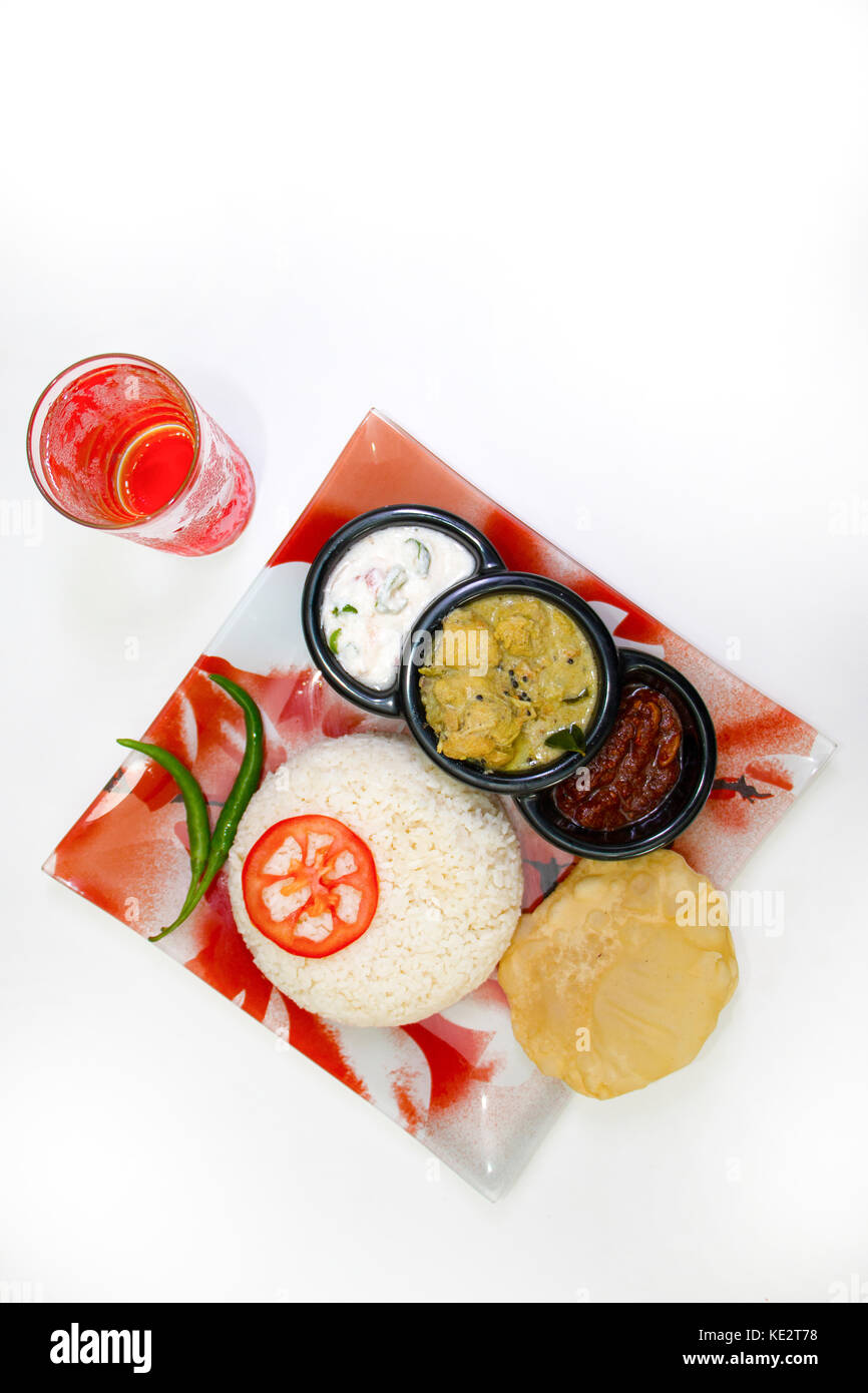 Indian Gee rice with complete curry meal served on a tray in a ...