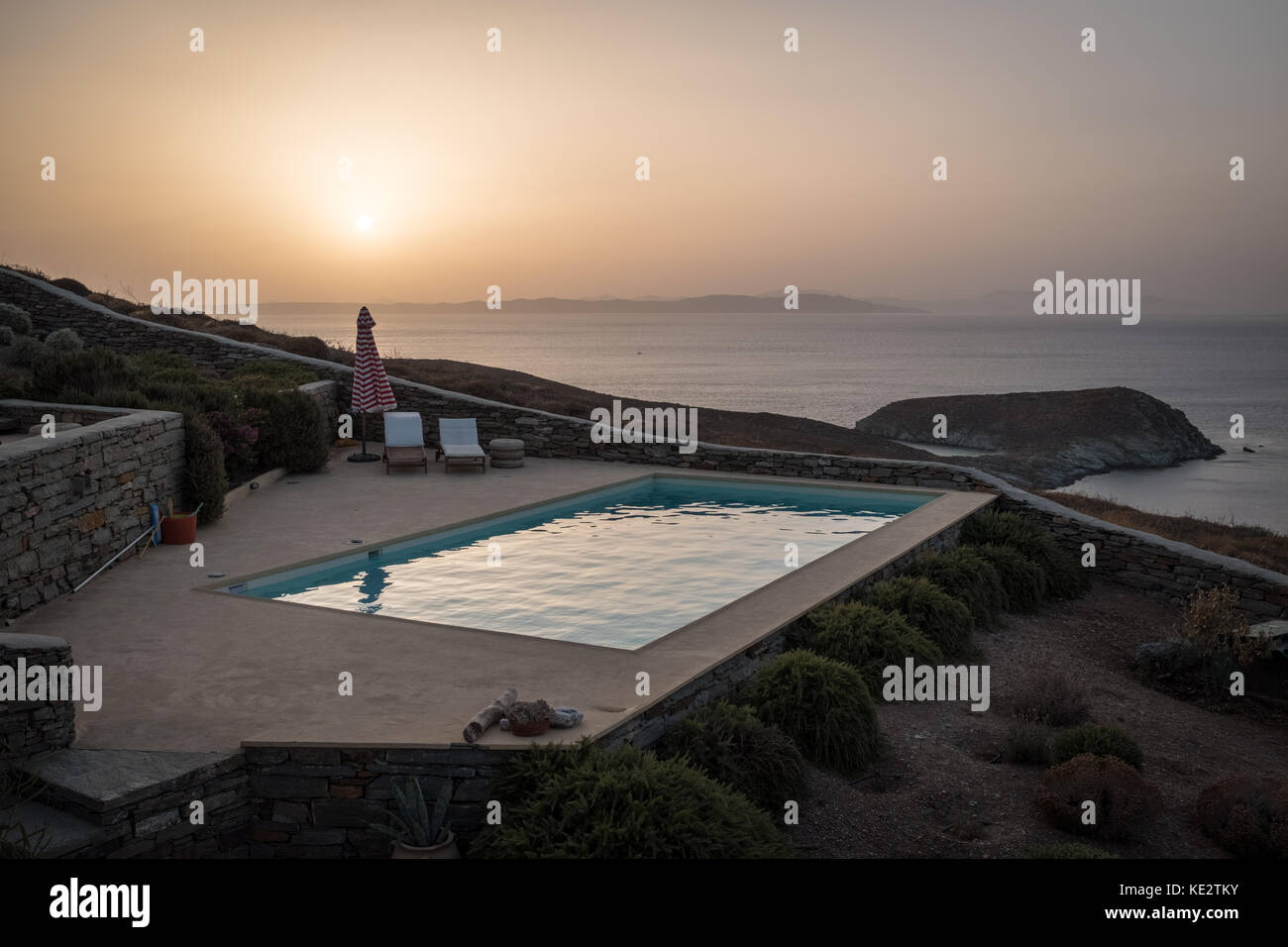 Swimming pool overlooking Aegean Sea at sunset, Kea, Grrece Stock Photo ...