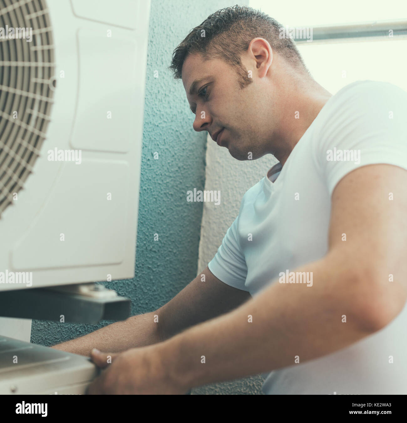 Male technician installing air-conditioning system Stock Photo - Alamy