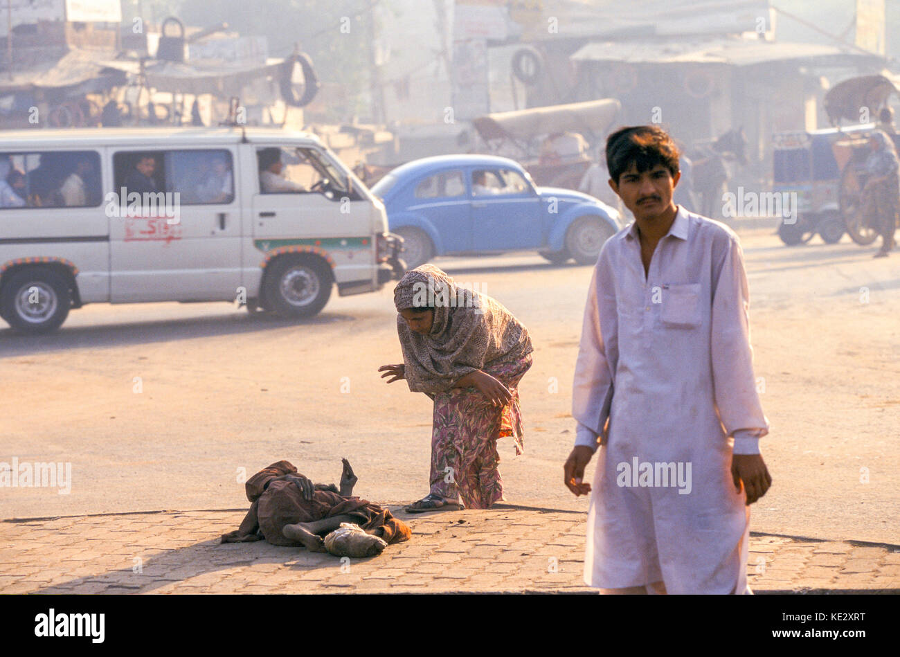 'LAHORE - PAKISTAN', A BEGGAR LIES IN THE STREET ATTRACTS THE ATTENTION ...