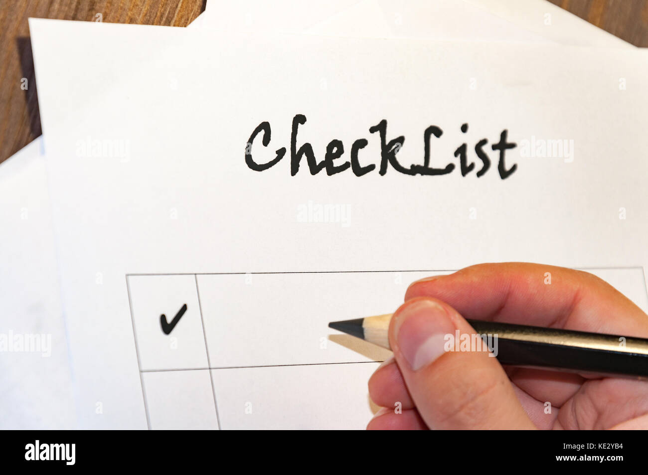 blank checklist on wooden table A sheet of paper in front of a man with ...