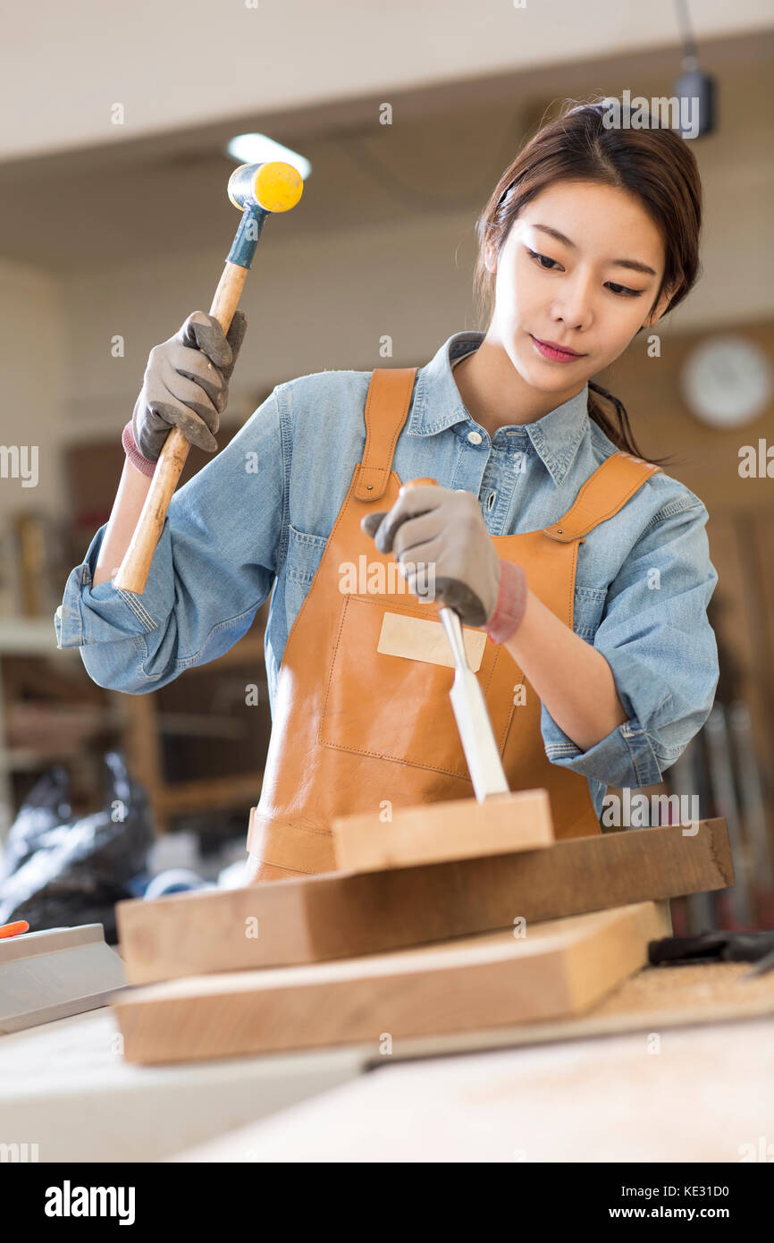 Portrait of young female woodworker concentrating on her work Stock ...