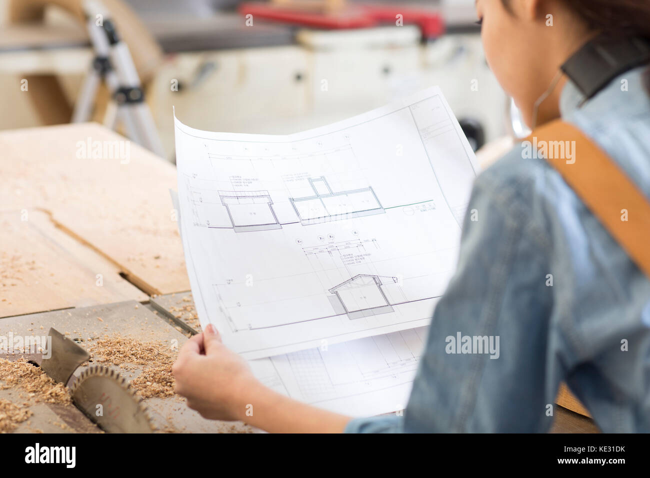 Back portrait of young female woodworker concentrating on her work ...