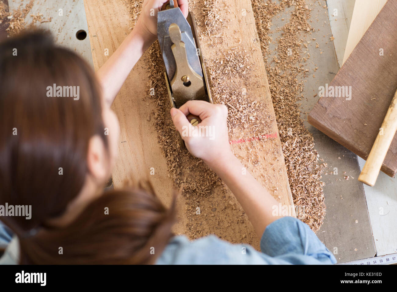 Back portrait of young female woodworker concentrating on her work ...