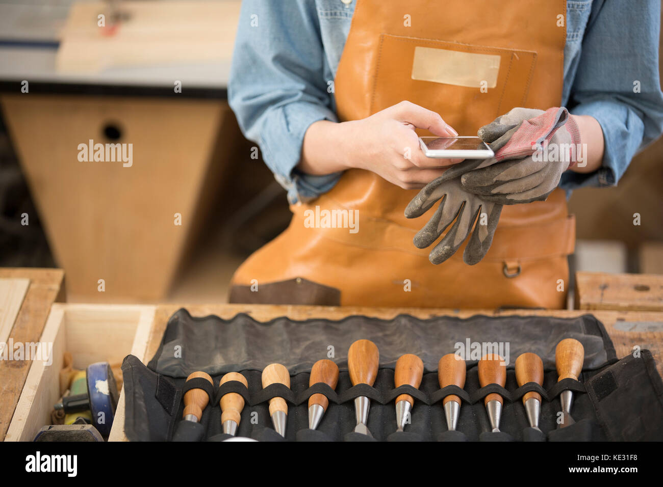 Young female woodworker using smartphone at work Stock Photo - Alamy