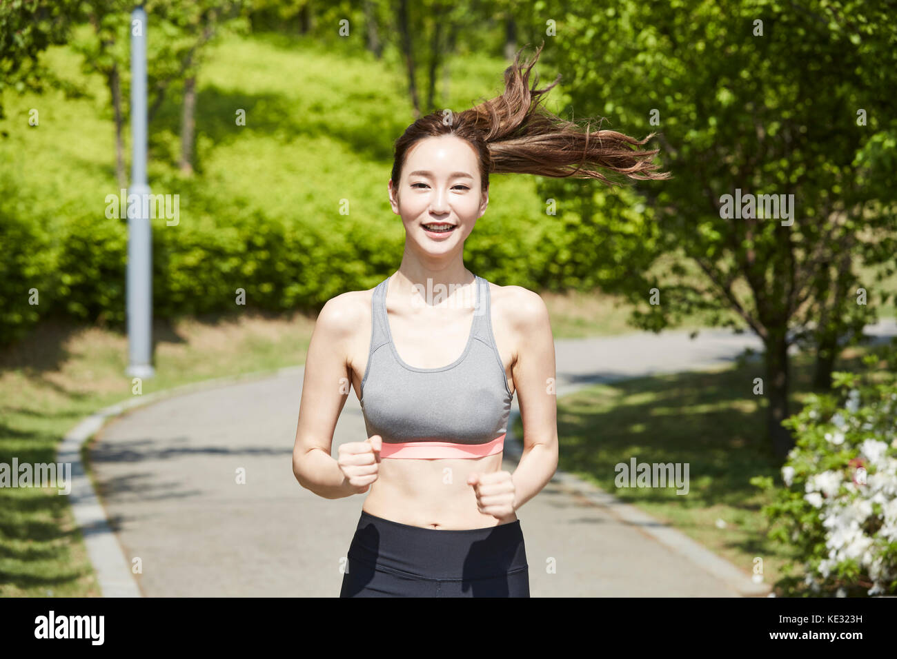 Young smiling slim woman jogging Stock Photo - Alamy