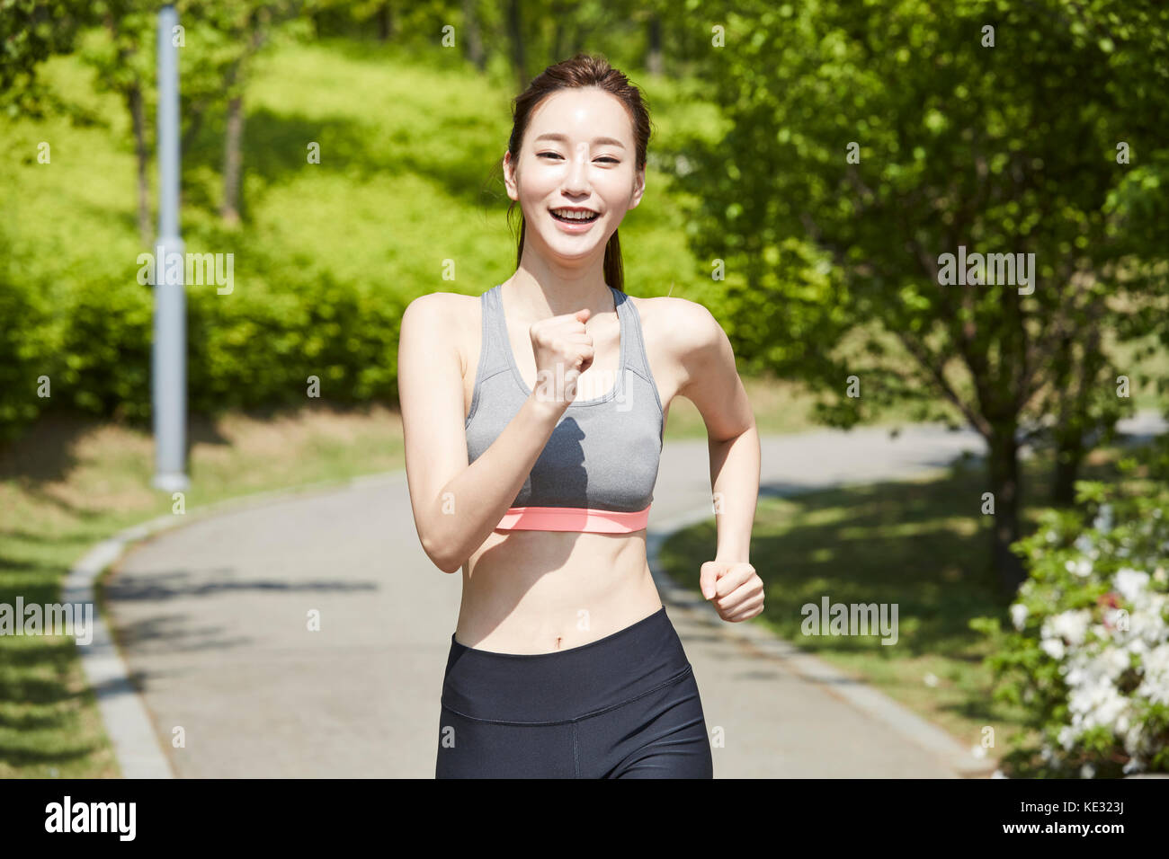 Young smiling slim woman jogging Stock Photo - Alamy