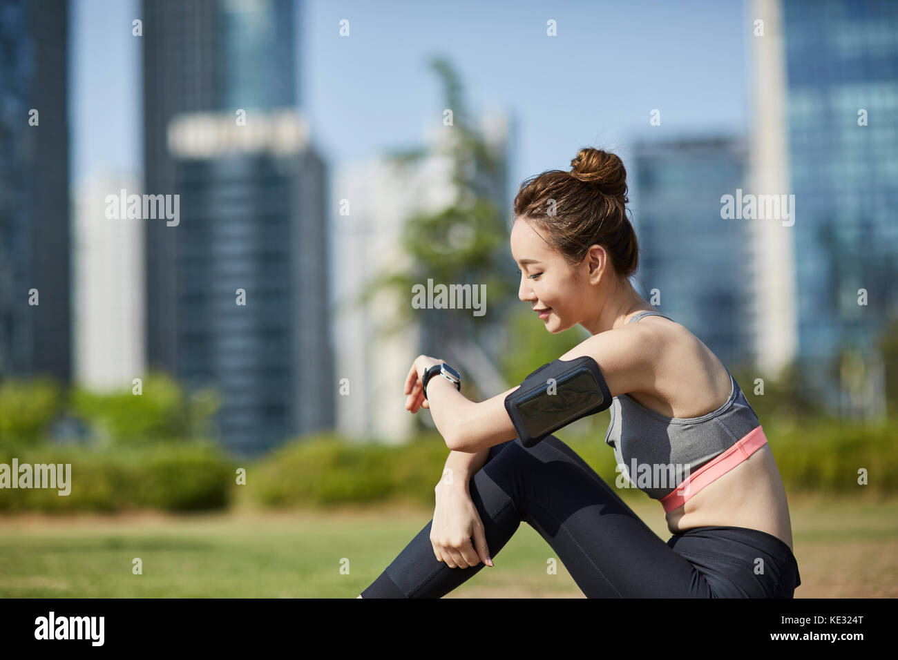 Side view of young smiling woman sitting watching her smart watch Stock ...