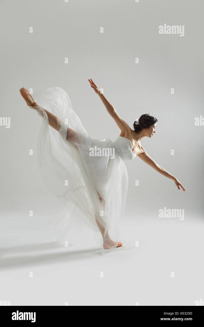 Side view of young ballerina in white dress posing elegantly Stock ...