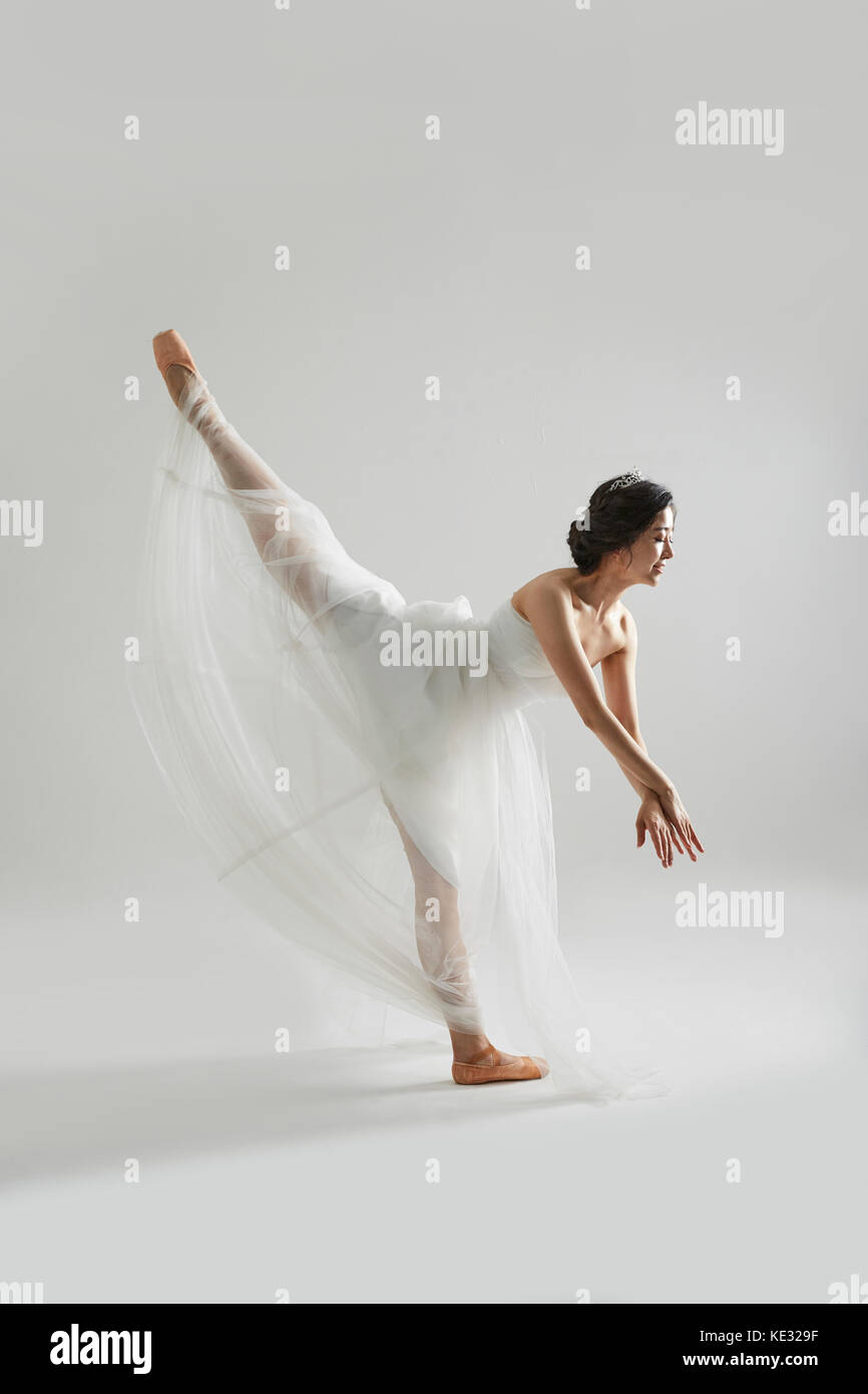 Side view of young ballerina in white dress posing elegantly Stock ...