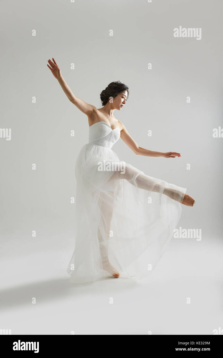 Side view of young ballerina in white dress posing elegantly Stock ...