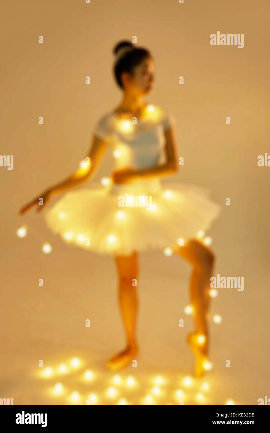 Side view of young smiling elegant ballerina under the lights, out of ...