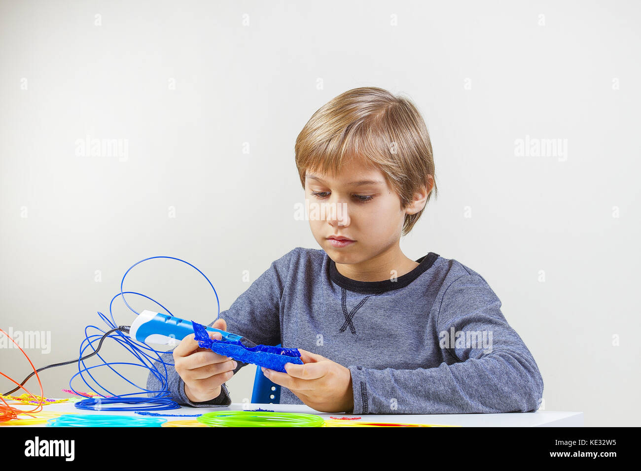 Focused child creating with 3d printing pen Stock Photo - Alamy