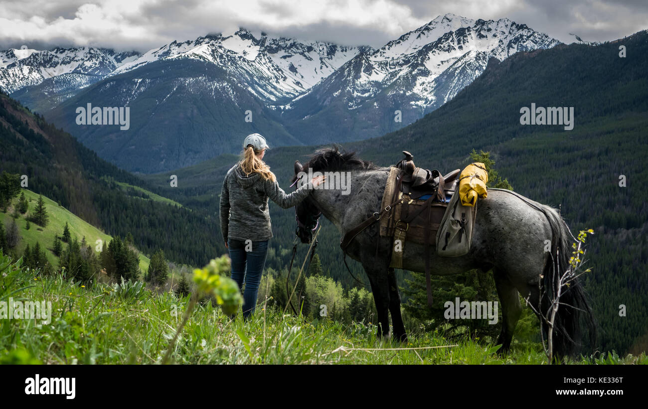 A female guide and her blue roan gelding travelling together through ...