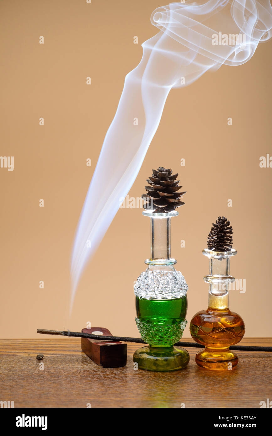 Small bottles of perfume dacorated with smoke from aromatic sticks ...