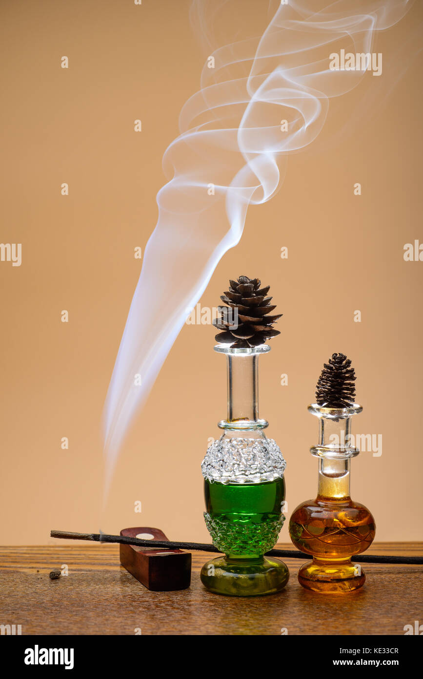 Small bottles of perfume dacorated with smoke from aromatic sticks ...