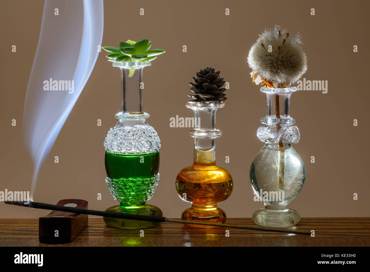 Small bottles of perfume dacorated with smoke from aromatic sticks ...