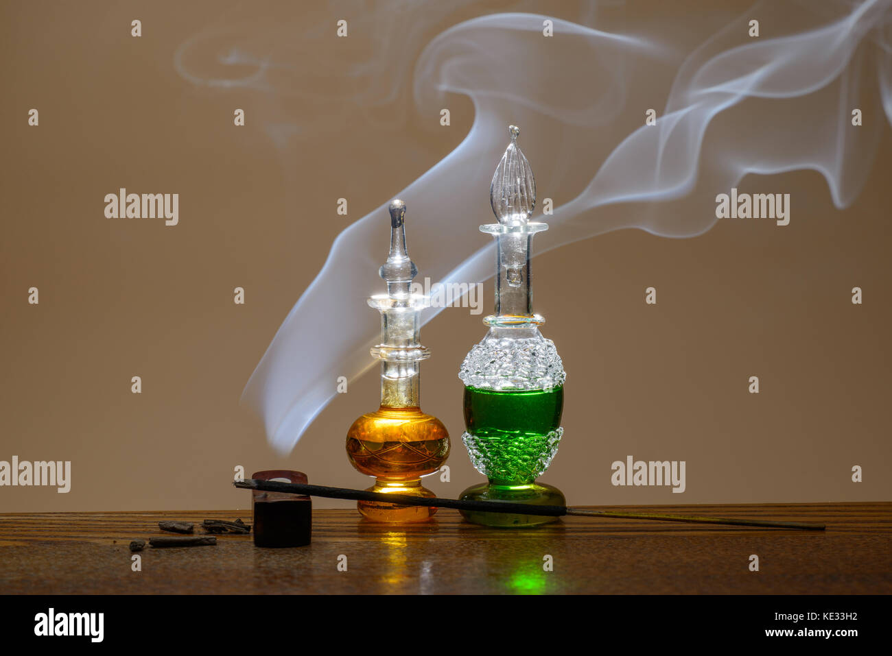 Small bottles of perfume dacorated with smoke from aromatic sticks ...