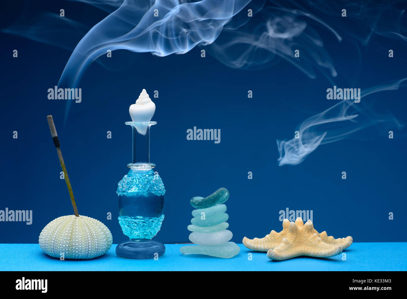 Small bottles of perfume dacorated with smoke from aromatic sticks ...