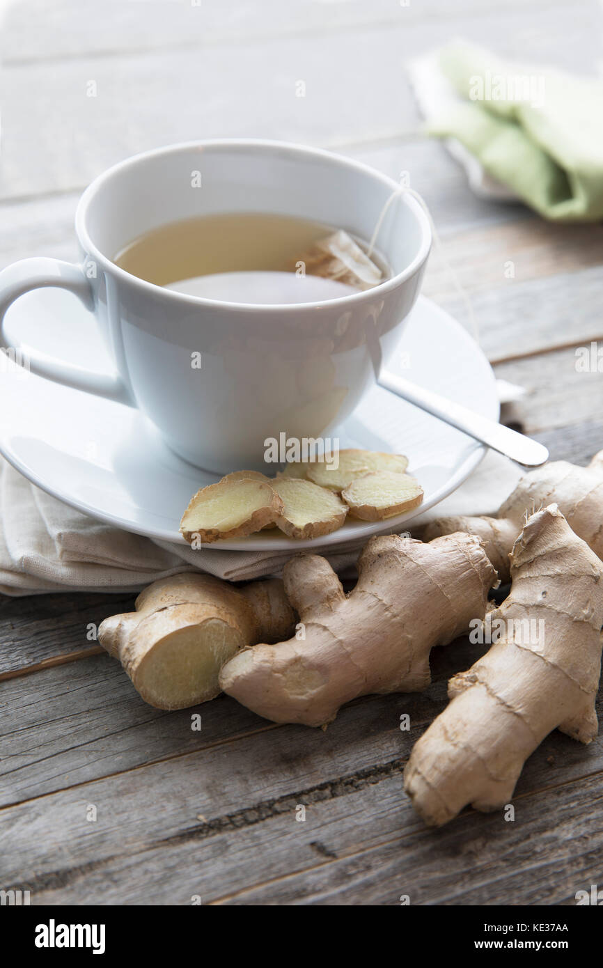Cup of hot ginger tea with ginger slices and ginger root, vertical ...