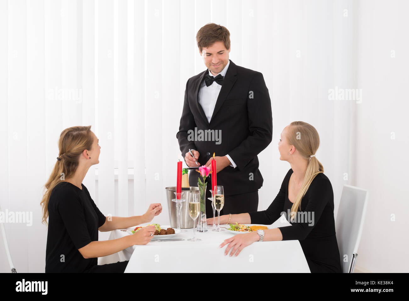 Waiter Taking An Order From Happy Female Friends In restaurant Stock ...