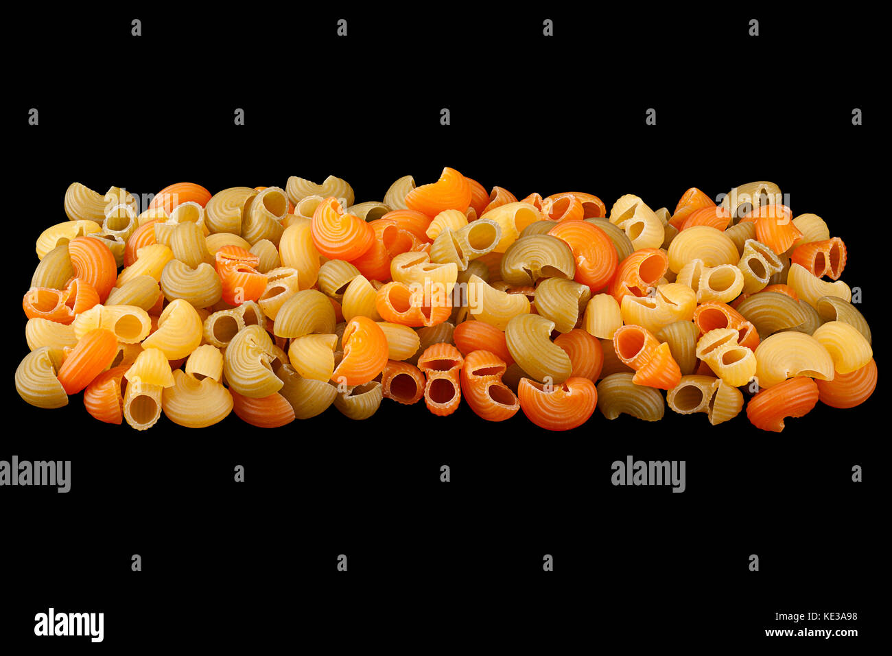 Multicolor dry swirl pasta isolated on black background Stock Photo - Alamy