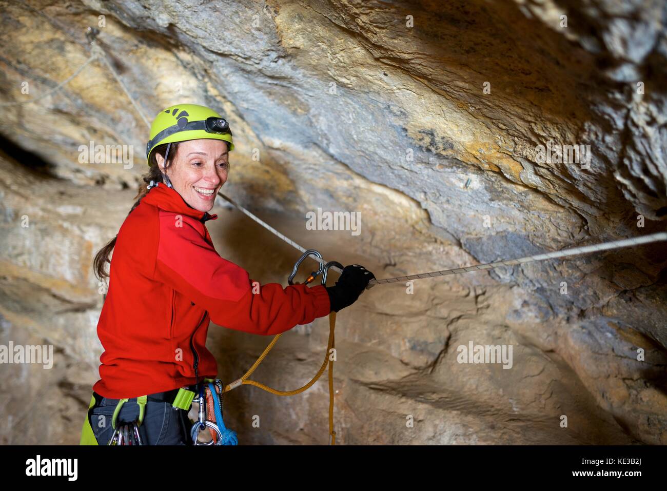 Speleologist performing rope maneuvers in a cave. Zaragoza Province ...