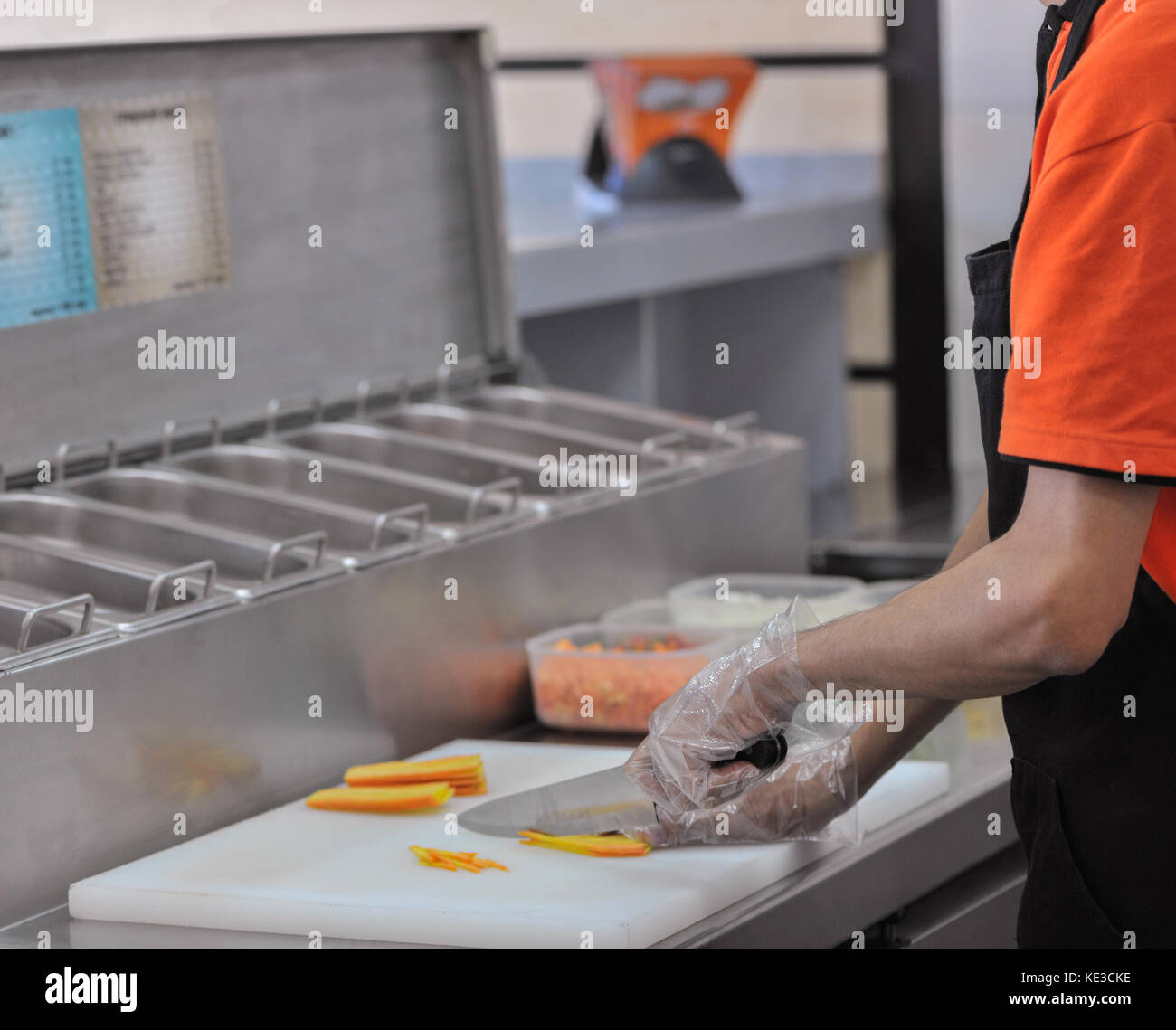 Chef cuts the vegetables in fast food restaurant. cook in the kitchen ...