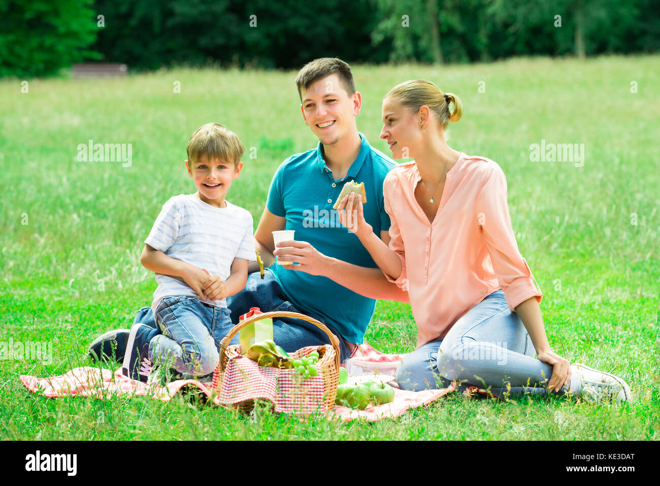 Smiling Parents With Son Enjoying Breakfast In The Park Stock Photo - Alamy
