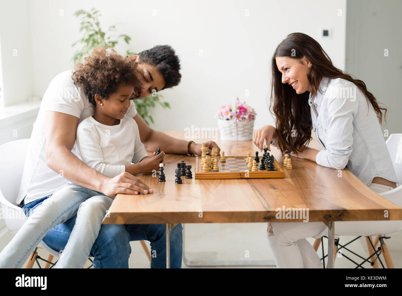 Happy family playing chess together at home Stock Photo - Alamy