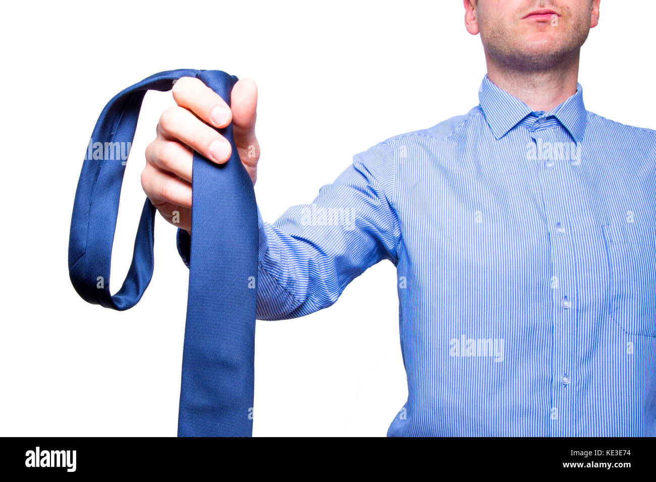 Young successful businessman taking tie off over white background ...