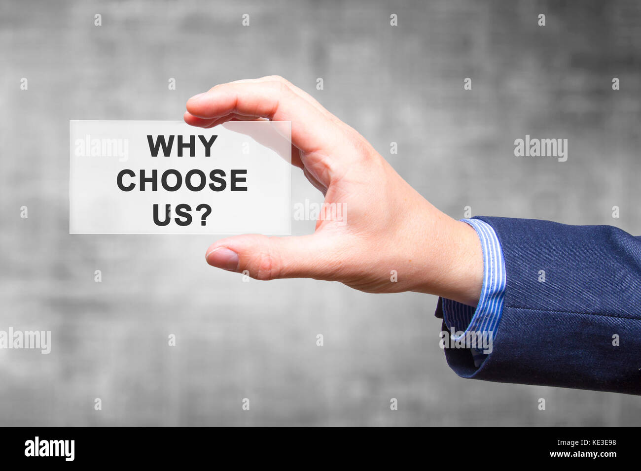 Businessman hand holding Why Choose Us? sign isolated on grey ...