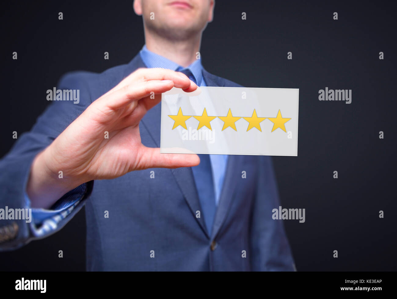 Businessman hand holding five stars isolated on black background ...