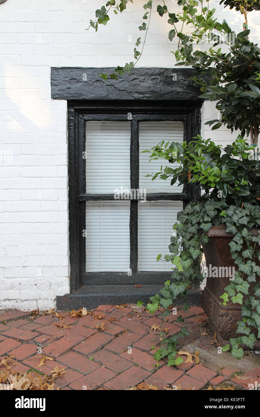 A ground level window of an old brick building. American colonial ...