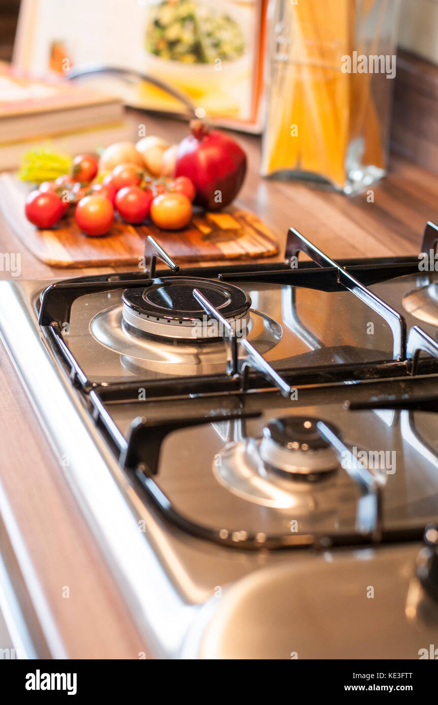 Gas hob with recipe book and vegetables Stock Photo - Alamy