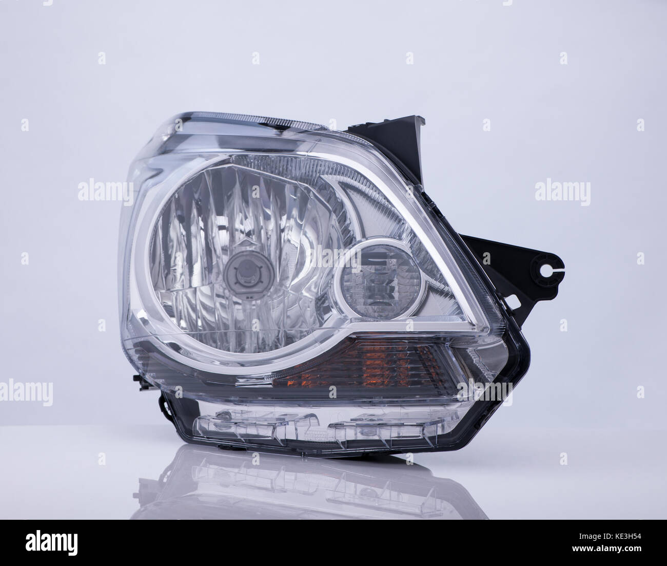 closeup of a car headlight on white background with reflection ...