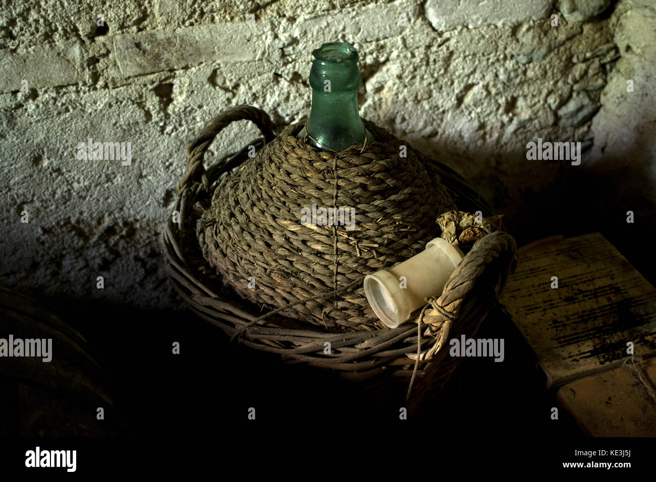 old straw-covered demijohn with aged red wine Stock Photo - Alamy