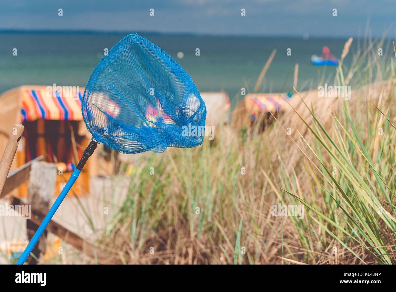 Blue hand net on the beach. Roofed wooden chairs on sandy beach in ...